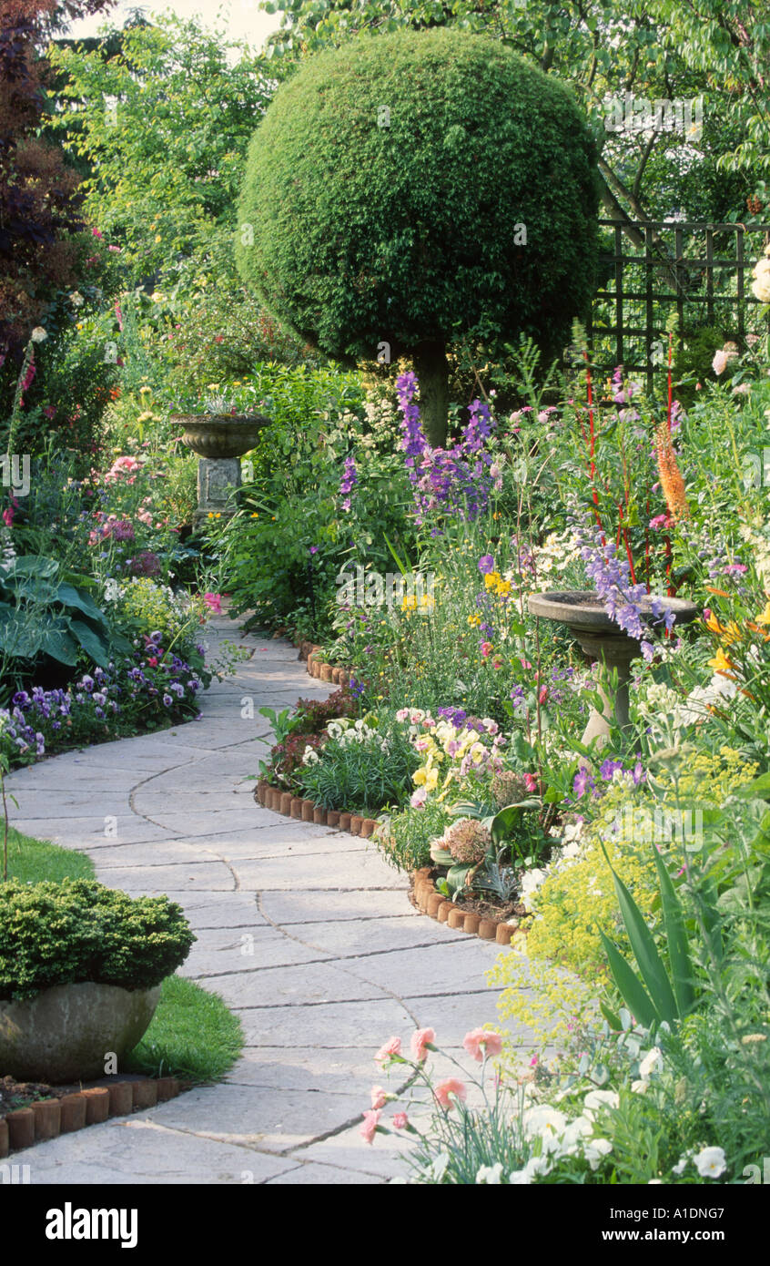 curving path through well planted garden with wooden edging Stock Photo ...