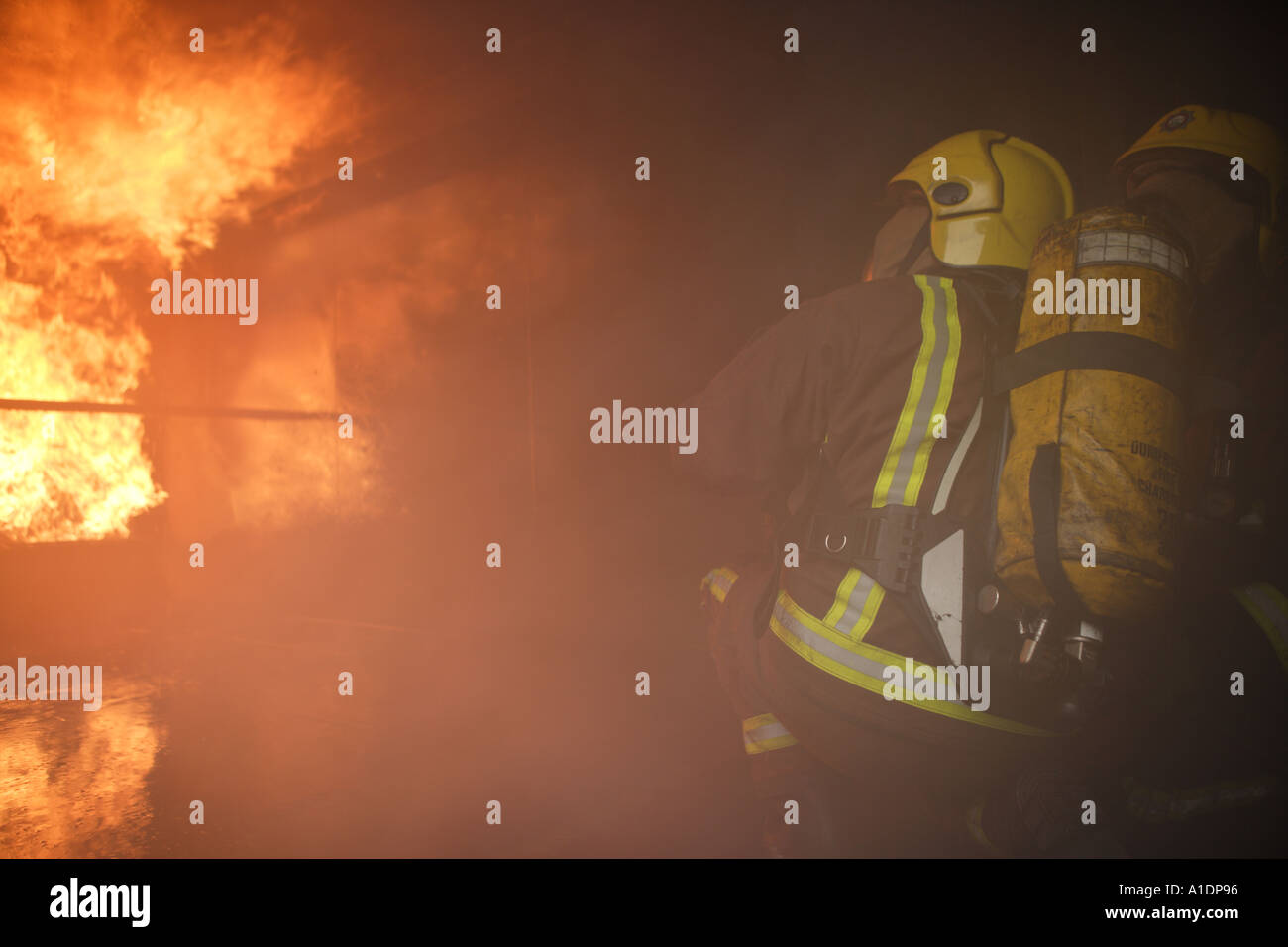 Fire fighter amoungest the flames fighting a fire Stock Photo - Alamy
