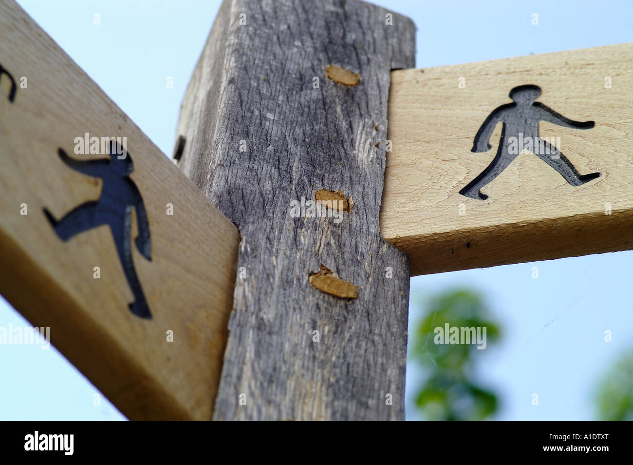 Tourist sign two direction post, two men silhouette walking opposite ...