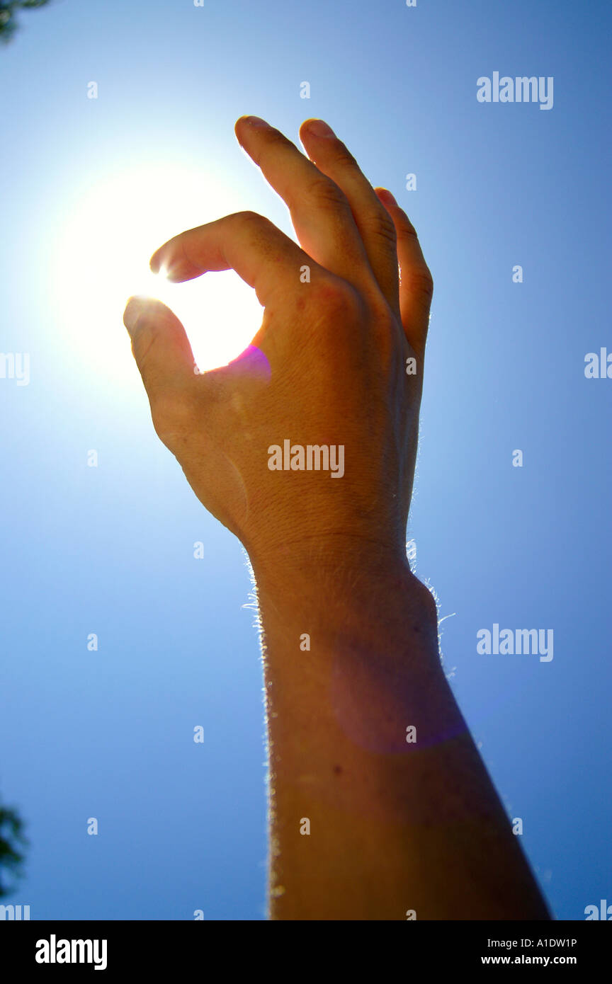 Hand palm over blue sky holding sun Stock Photo - Alamy