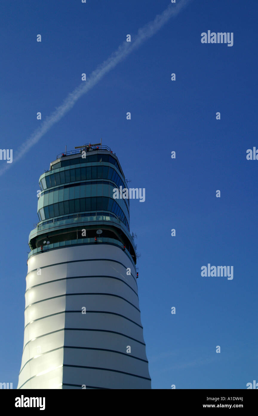 Air traffic control tower and blue sky and airplane condensation stripe ...