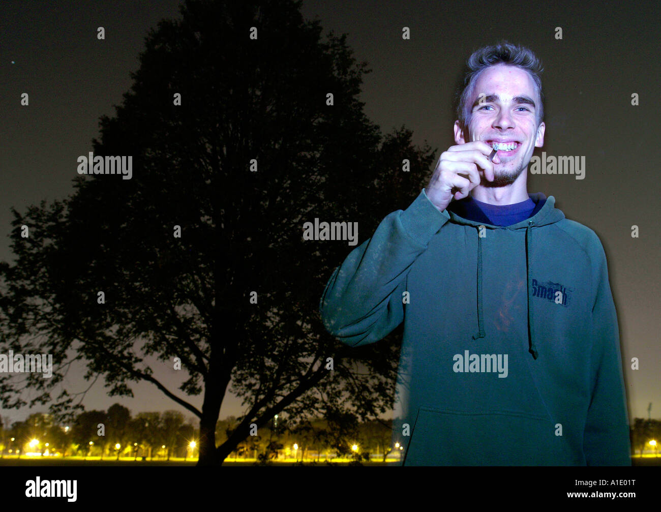 Night portrait of young teenage man boy smoking cigarette smiling happy ...