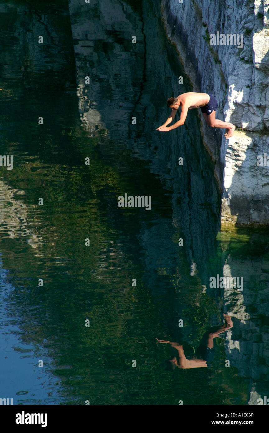 Man jumping into water pool from limestone cliff in central Krakow ...