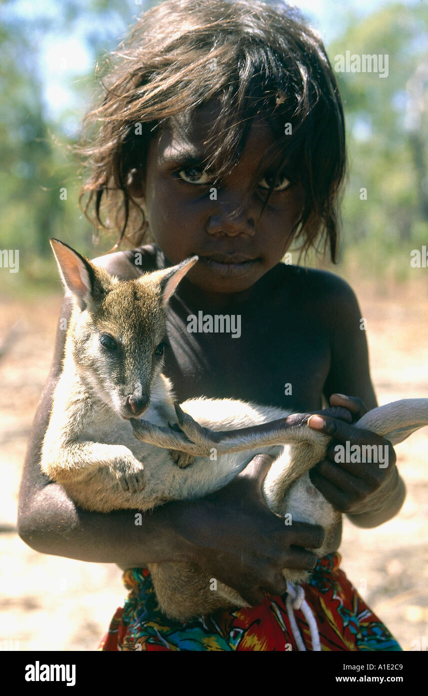 Aboriginal little girl Margie cuddles her pet joey a baby kangaroo ...