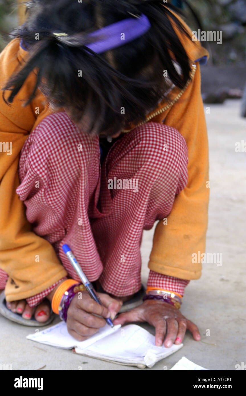 Young native indian girl child writing notes in indian alphabet into ...
