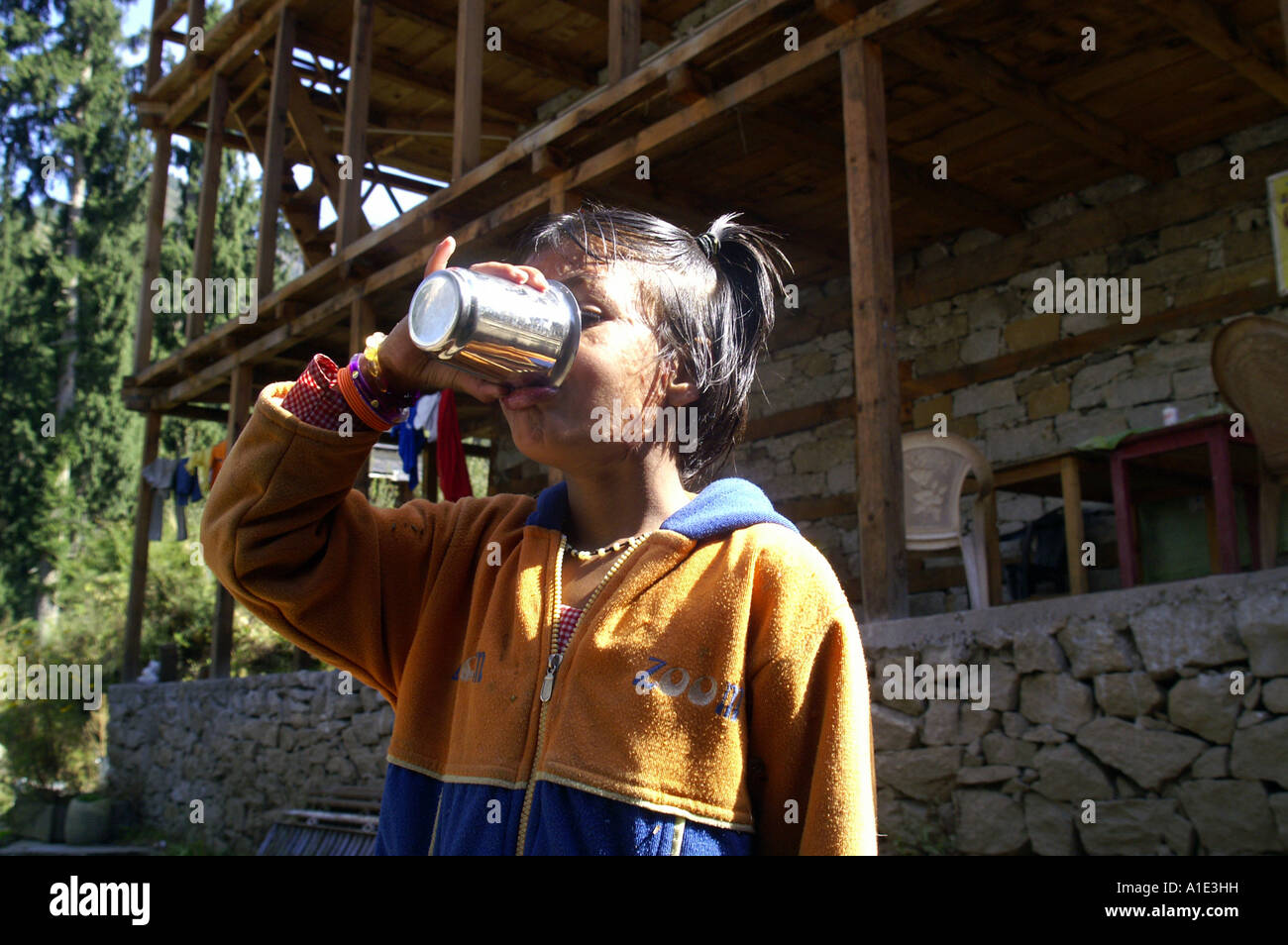One young native indian child girl drinking from metal mug, Kalga ...