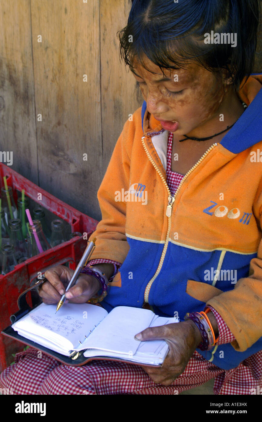One young native indian girl children writing notes in indian alphabet ...