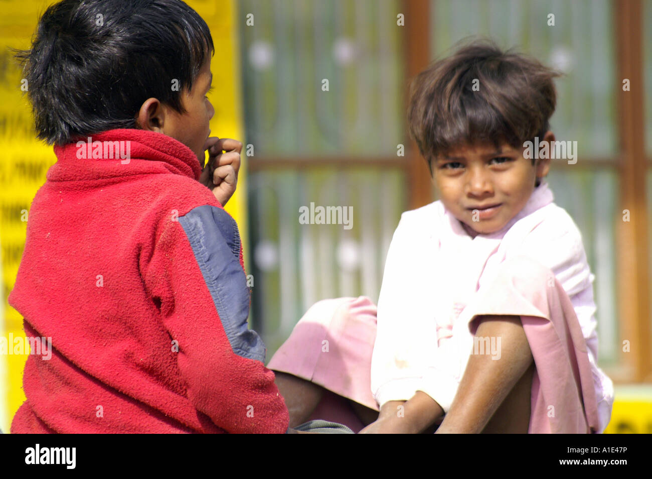 Two little indian boys girls children kids sitting on banister of ...