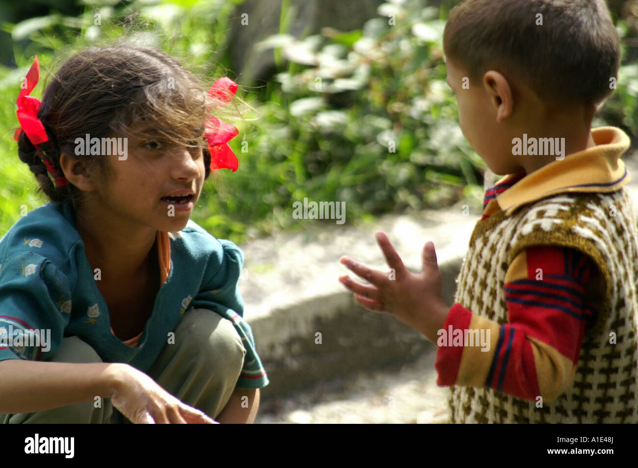 Two small indian children boy girl talking outdoors in garden Stock ...