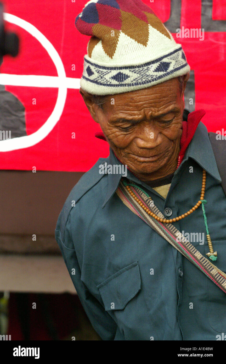 Old indian tibetan man wrinkles face portrait standing in front of red ...