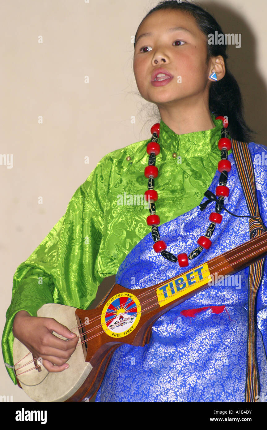 Young girl singer performer of tibetan arts music in front of pink ...