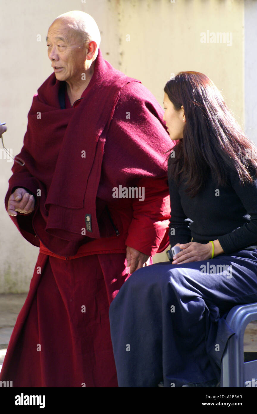 Old tibetan buddhist important man monk standing with pretty woman ...