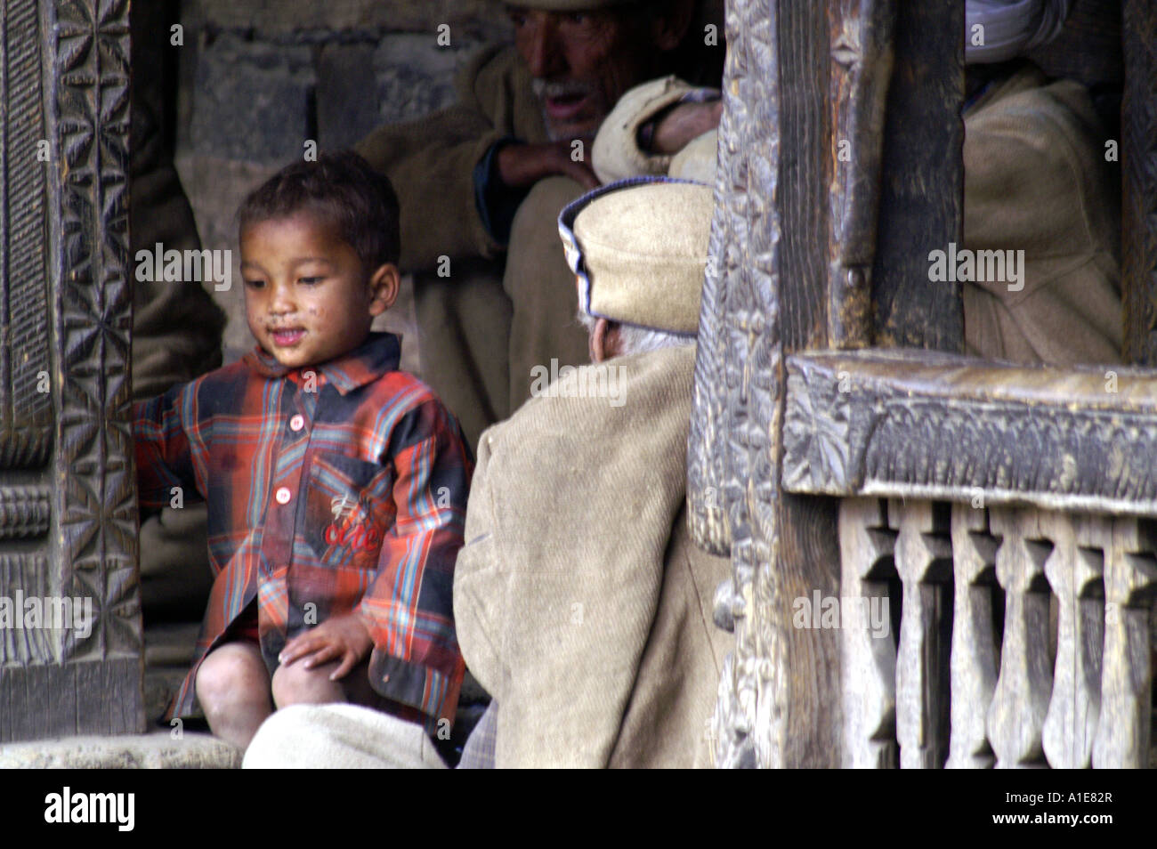 Child and high rank priests lingering in front of carved wooden temple ...