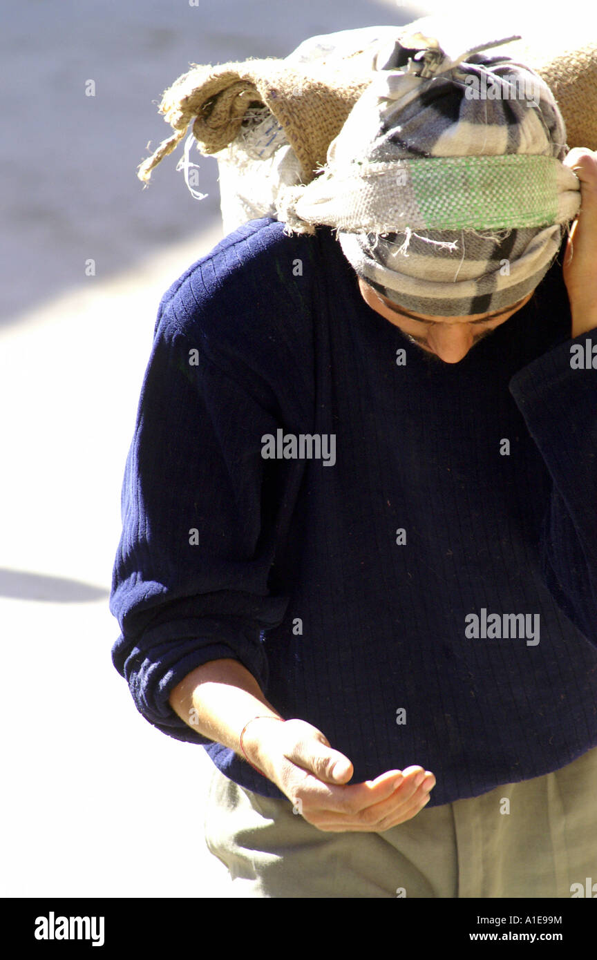 Indian man carrying heavy sack hanged tied on his head, hard working ...