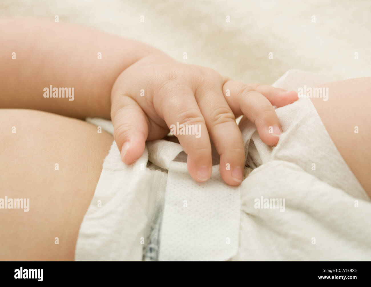 Baby's hand on diaper Stock Photo - Alamy