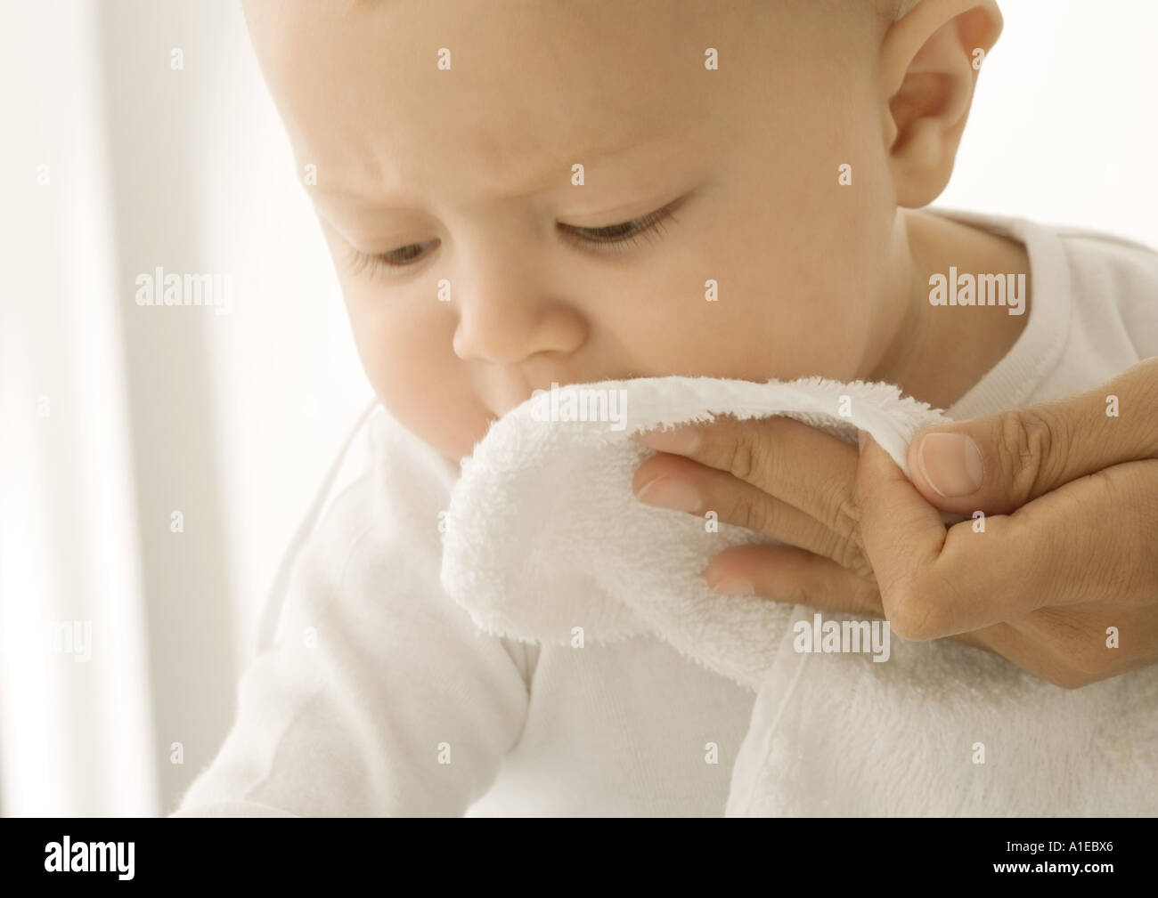 Baby having face wiped Stock Photo - Alamy