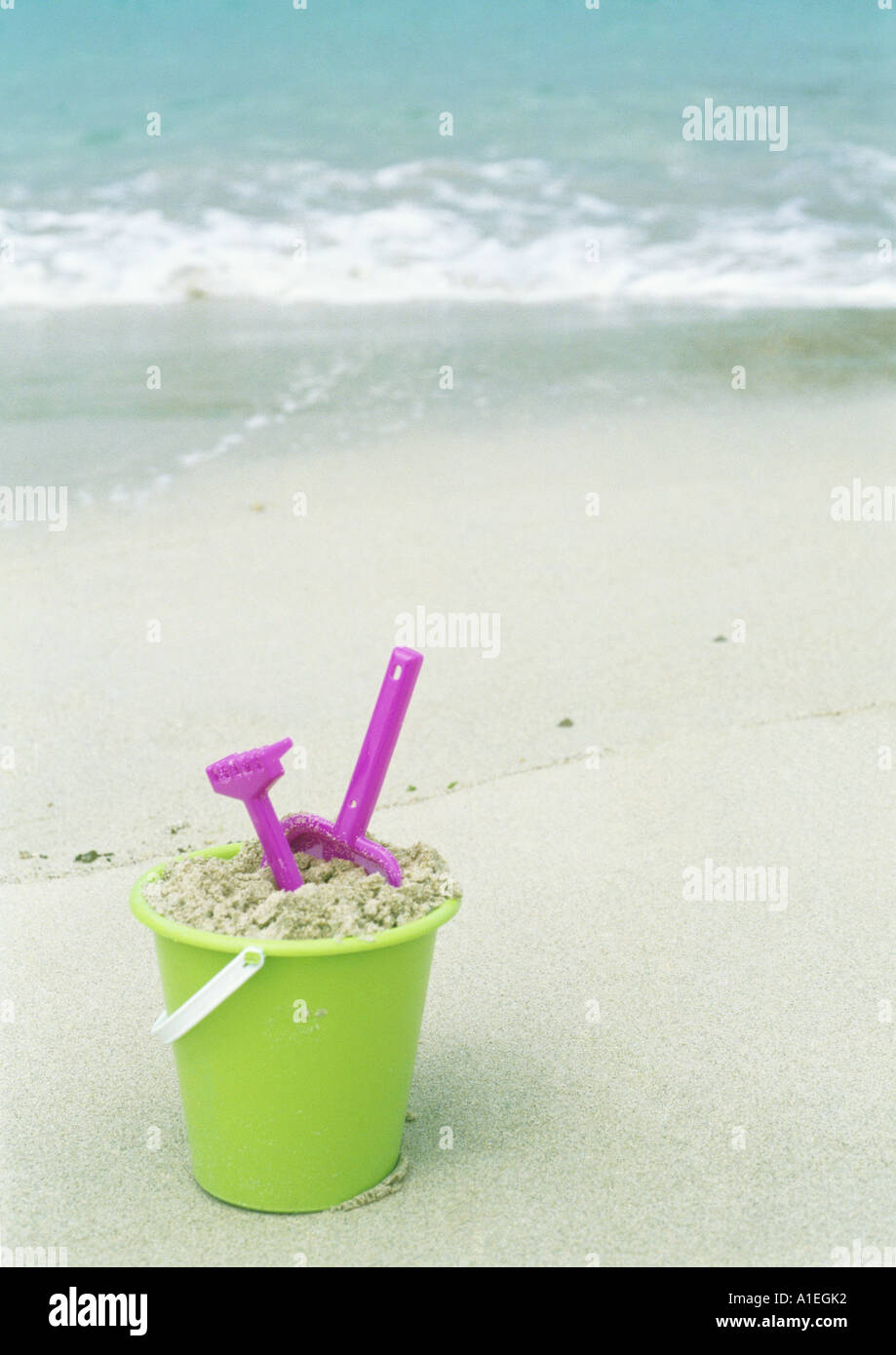 Bucket filled with sand and beach toys on beach Stock Photo - Alamy