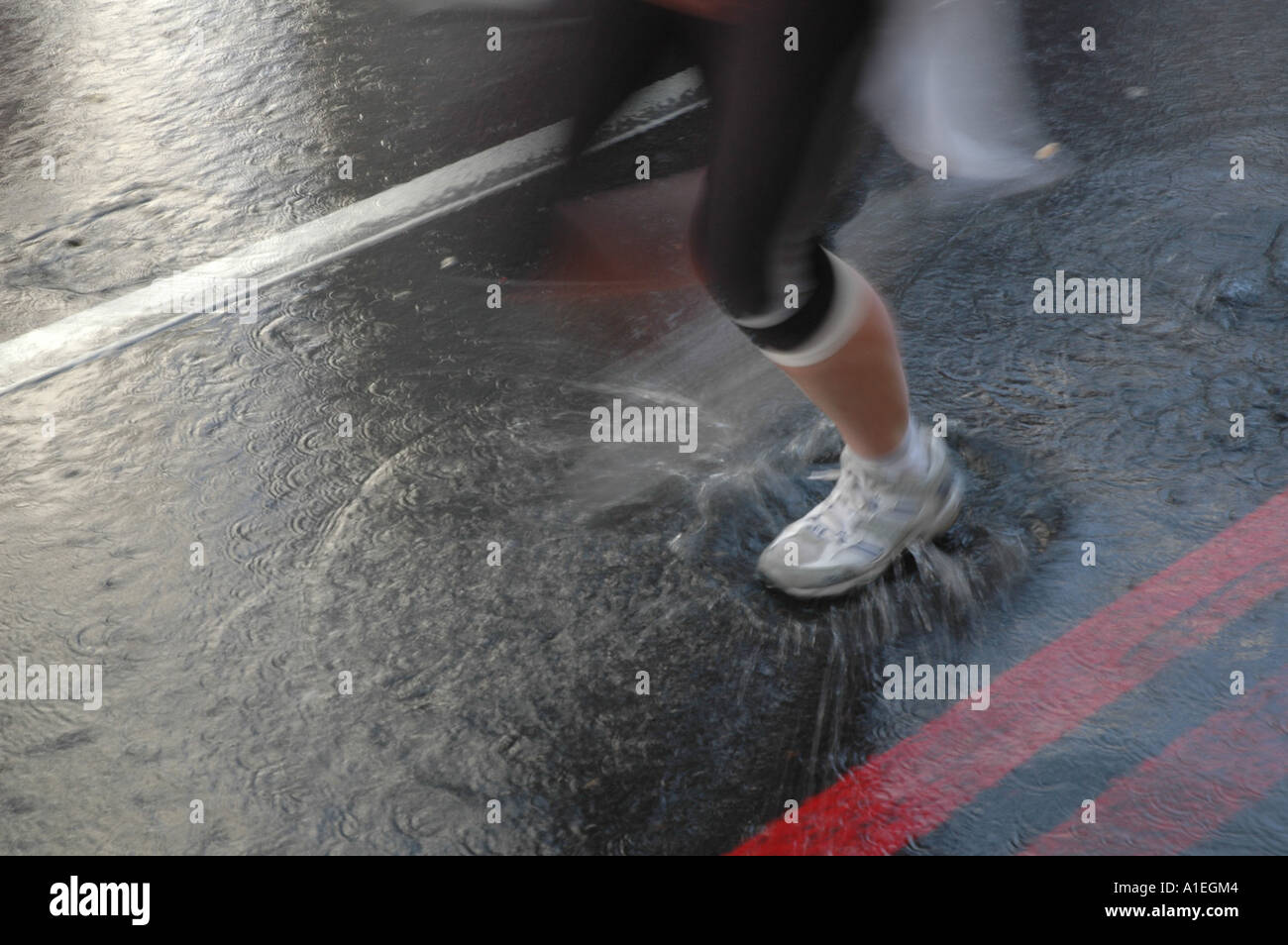 A Women Running Through a Puddle During the 2005 Flora London Marathon ...