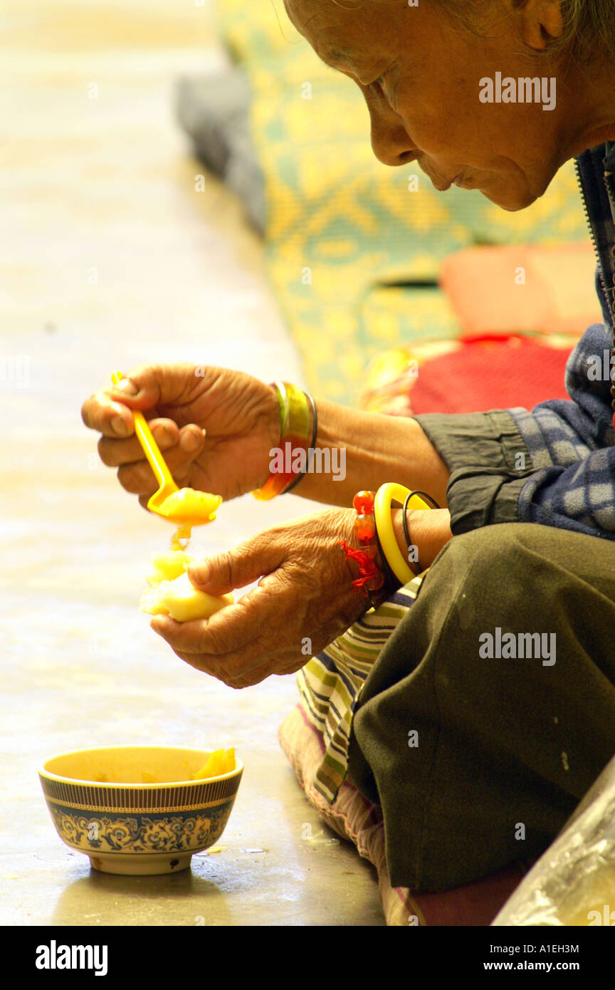 Female buddhist eating her lunch soup from china bowl in Namgyal ...