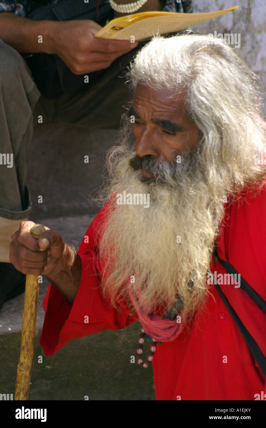 Old hindu sadhu holy man walking supported by wand at streets of McLeod ...