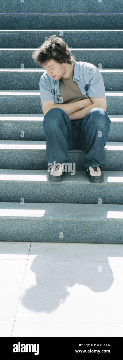 Young man sitting on steps Stock Photo - Alamy