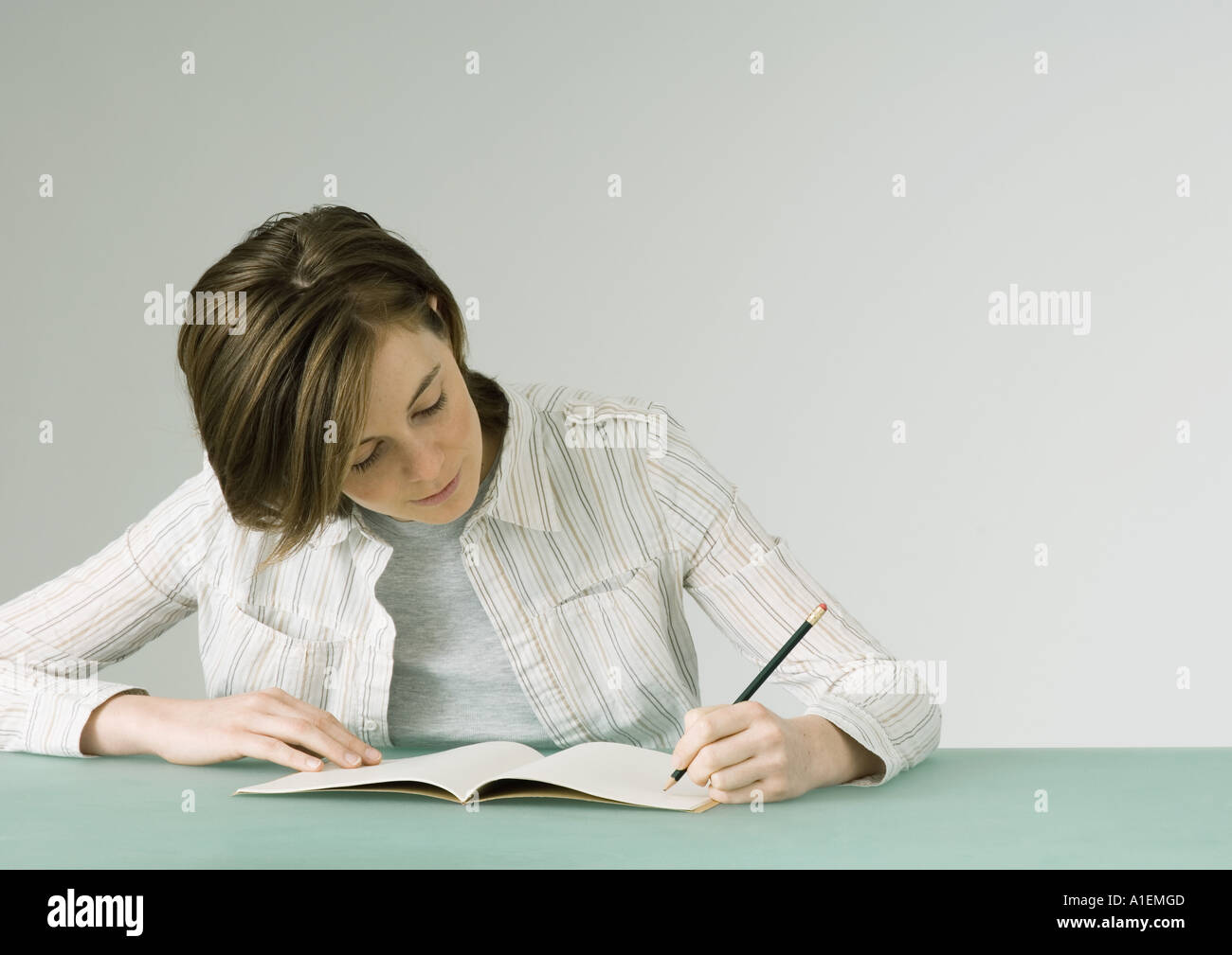 Young woman writing in notebook Stock Photo - Alamy