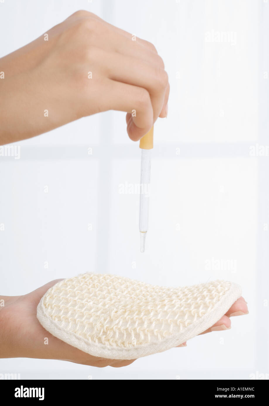 Woman's hands holding sponge and dropper Stock Photo - Alamy
