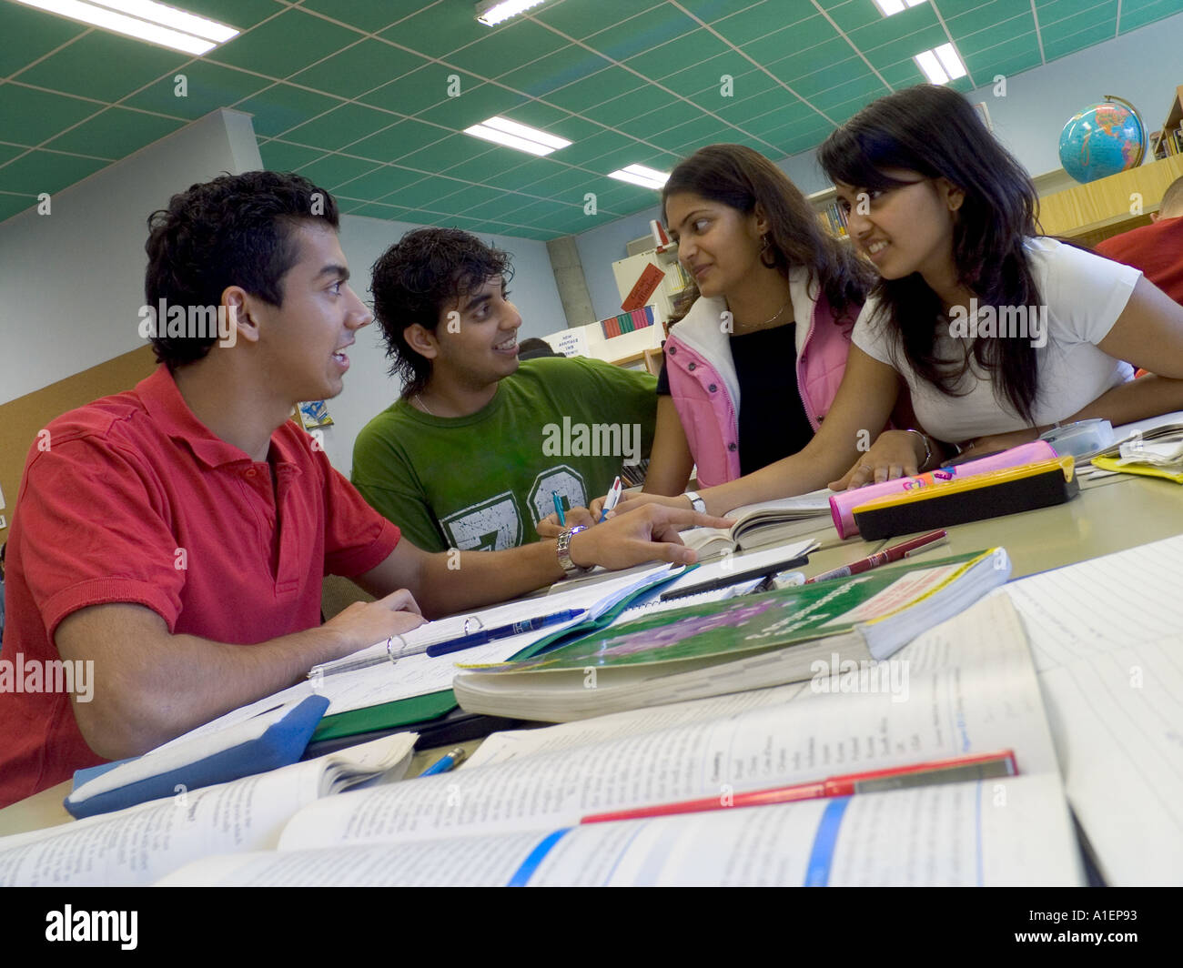 Multicultural group of teenage students working together in an informal ...