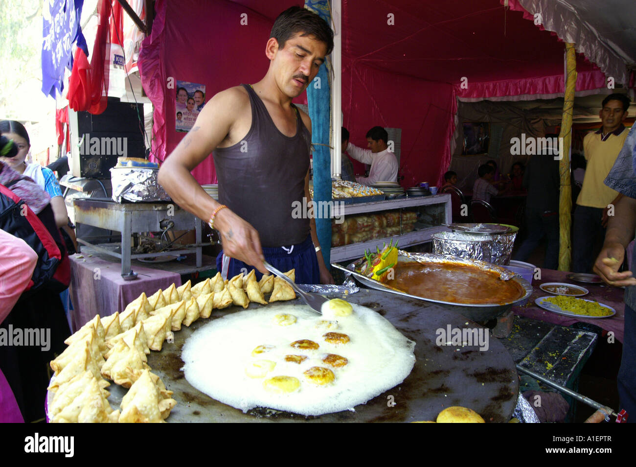 Man frying cakes at Dussehra fair with enormous variety of rich Indian ...