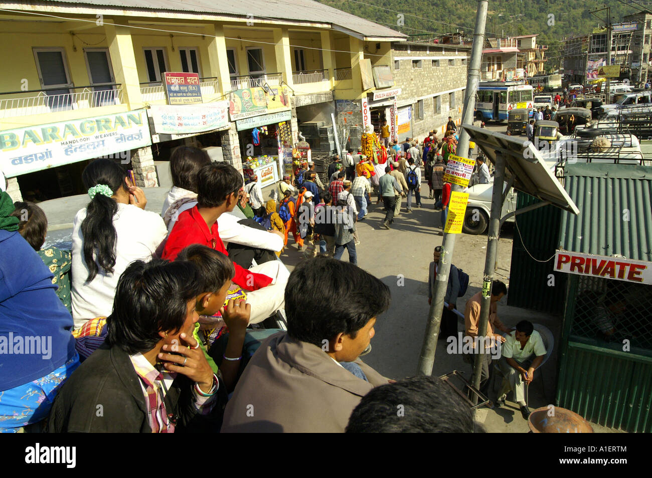 Crowds travelling on roof of overfull bus, Kullu town streets in India ...