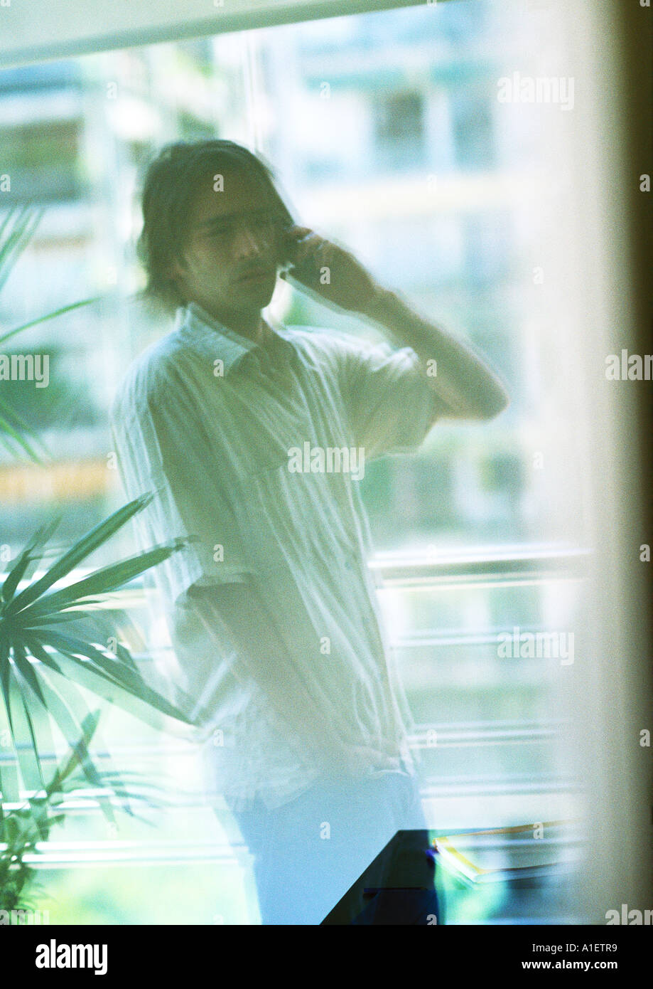 Reflection of man using phone Stock Photo - Alamy