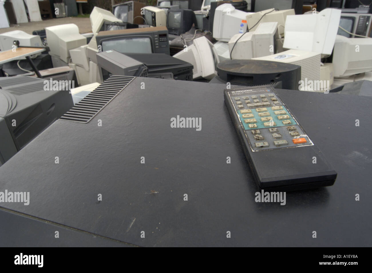 Television remote control on top of a TV with scrapped TVs and computer ...