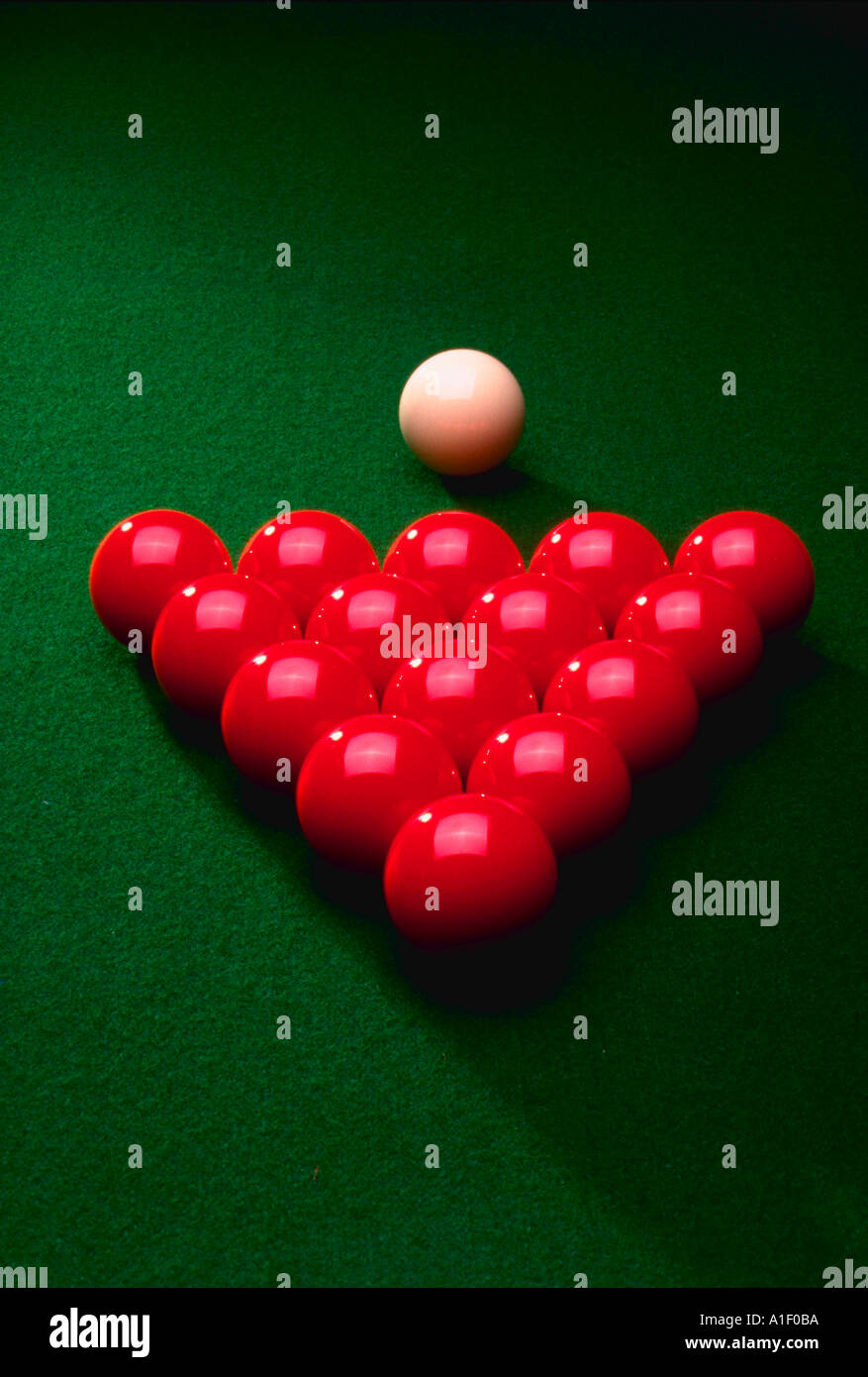 Red billiard balls and white cue ball laying on pool table in a ...
