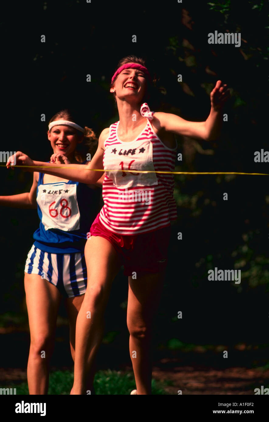 Woman runner breaking the tape Stock Photo - Alamy