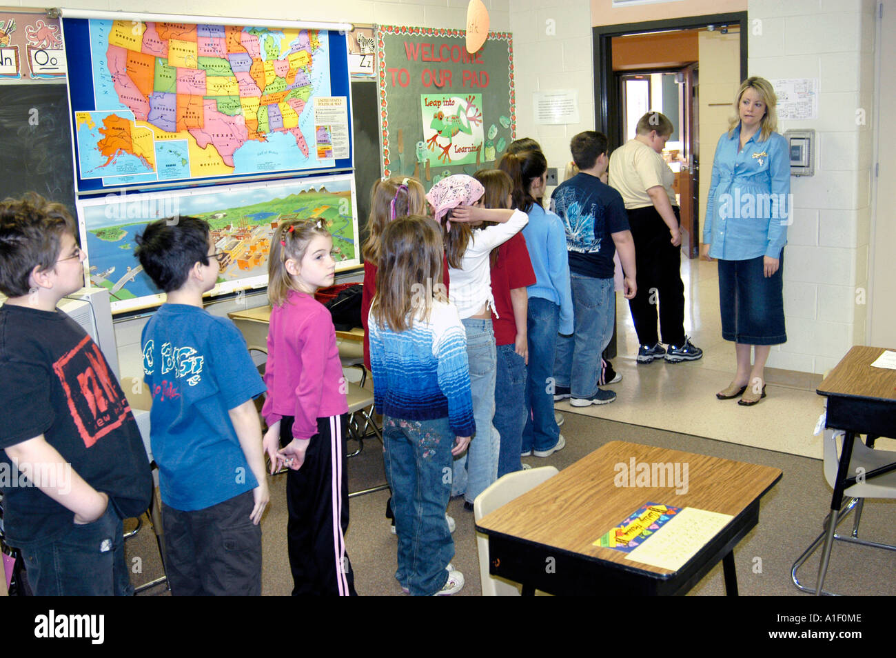 Pregnant woman teacher conducts lessons in her third grade classroom ...