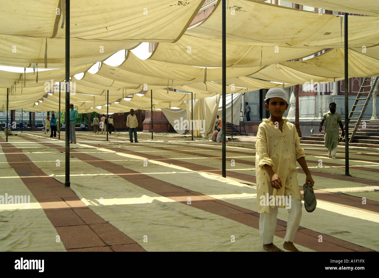 Muslim child under sun shelters in Jama Masjid mosque, New Delhi, India ...