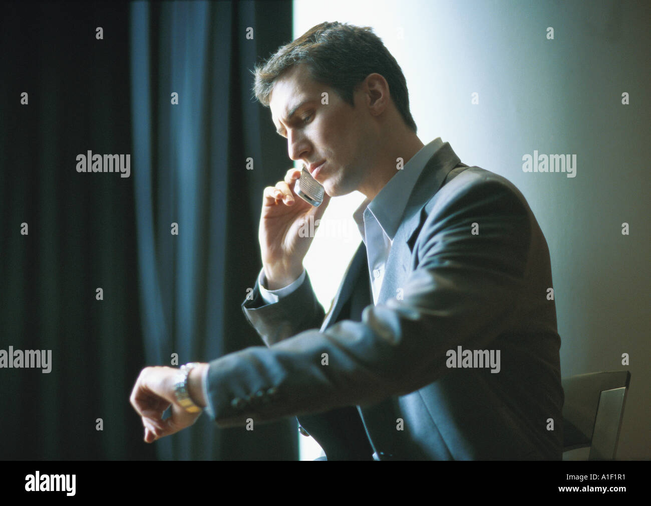 Businessman cell phone checking watch hi-res stock photography and ...