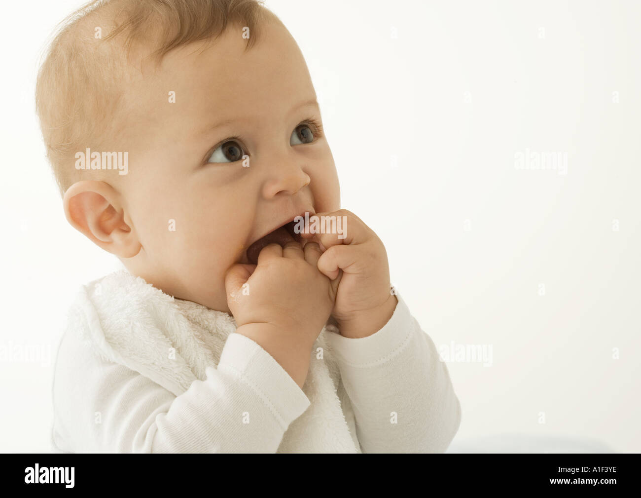 Baby with hands in mouth Stock Photo - Alamy