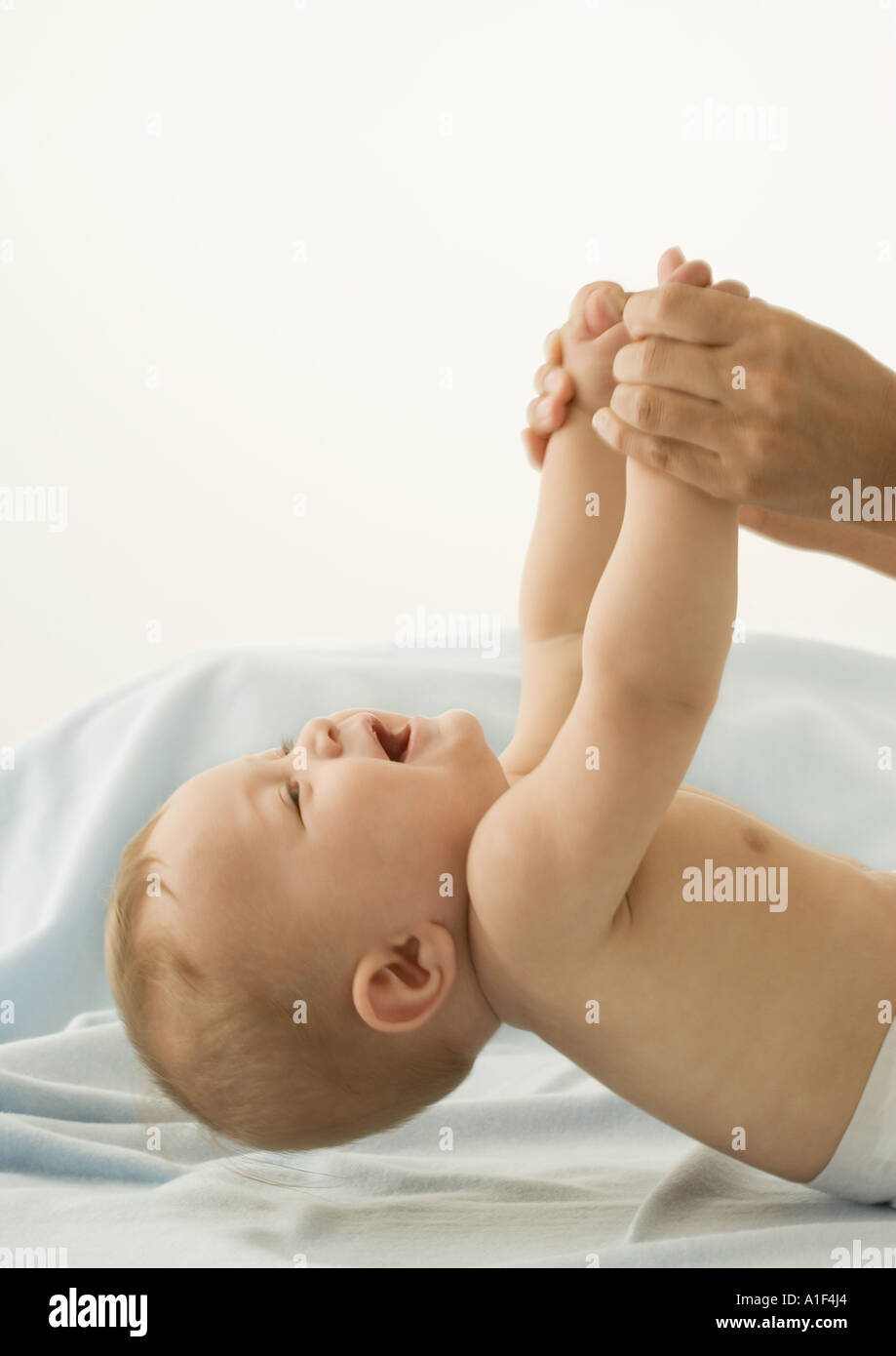 Parent lifting baby by hands. cropped Stock Photo - Alamy