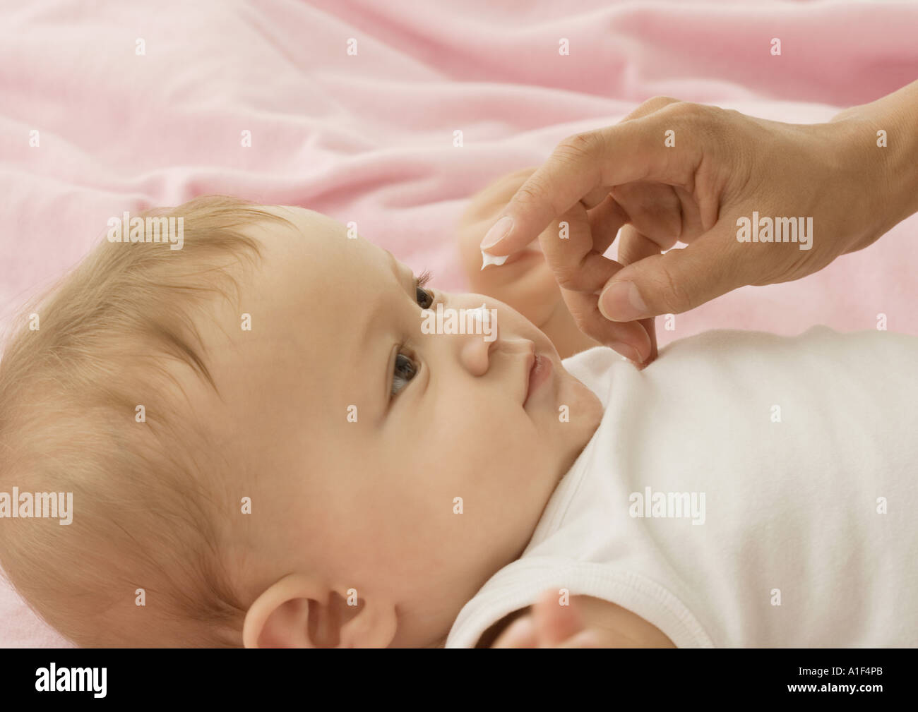Baby with dab of lotion on nose Stock Photo - Alamy
