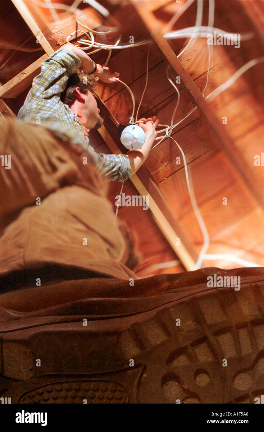 An electrician installing wiring on a house under construction Stock ...