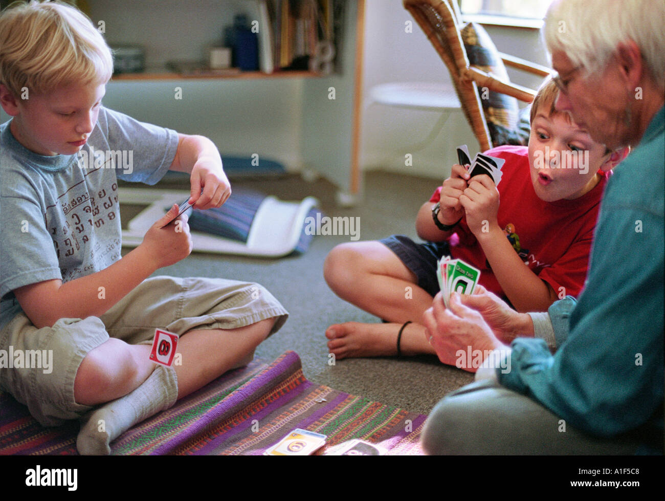 A grandmother and her two grandchildren playing cards at home Stock ...