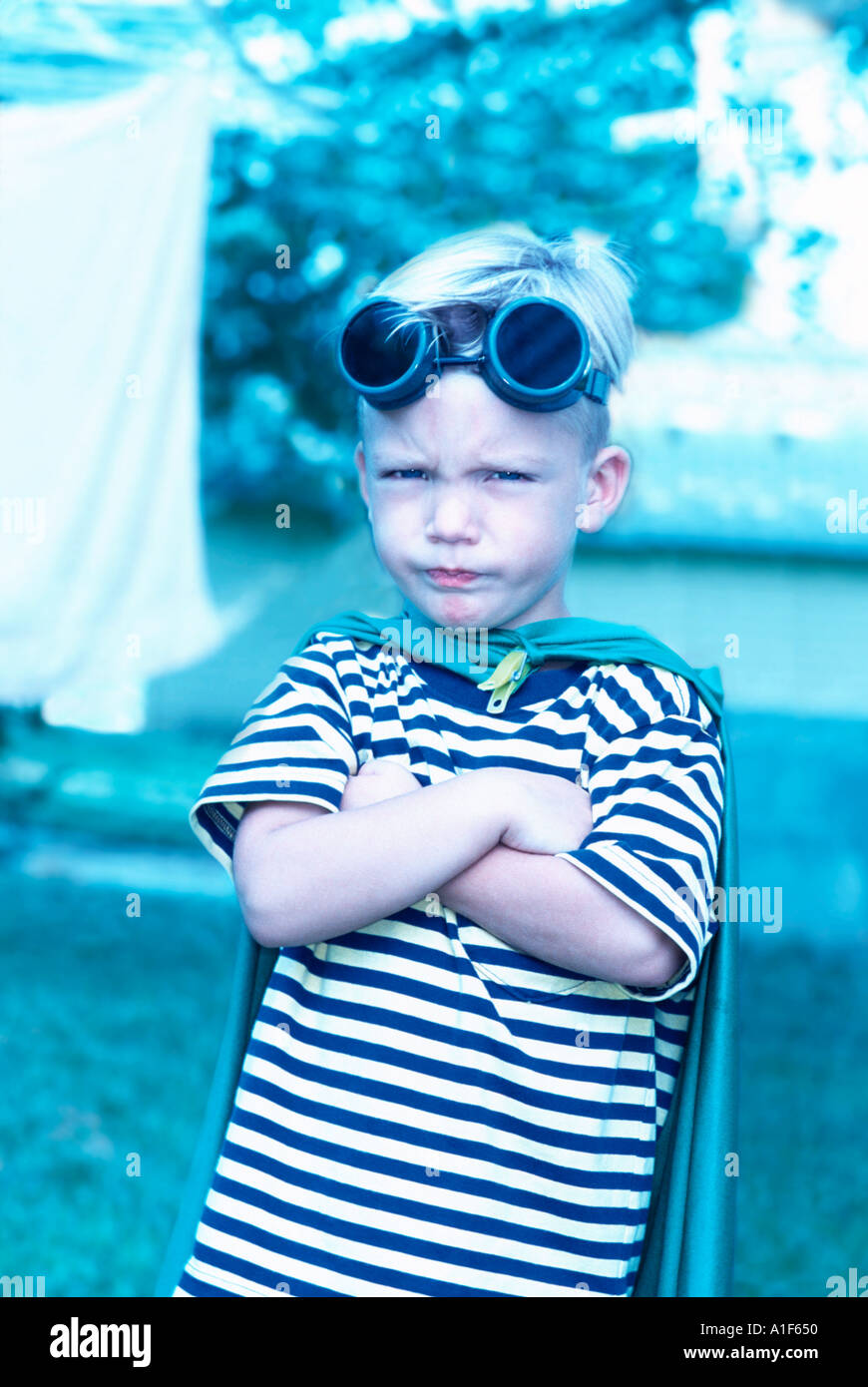 Young boy in cape pouting outdoors Stock Photo - Alamy