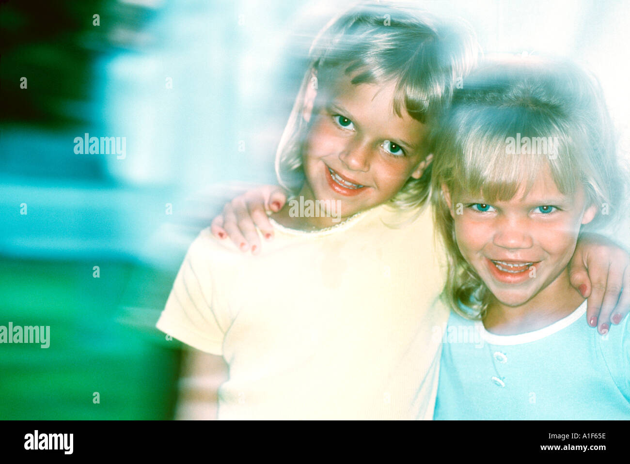 Two young girls with arms around each other Stock Photo - Alamy