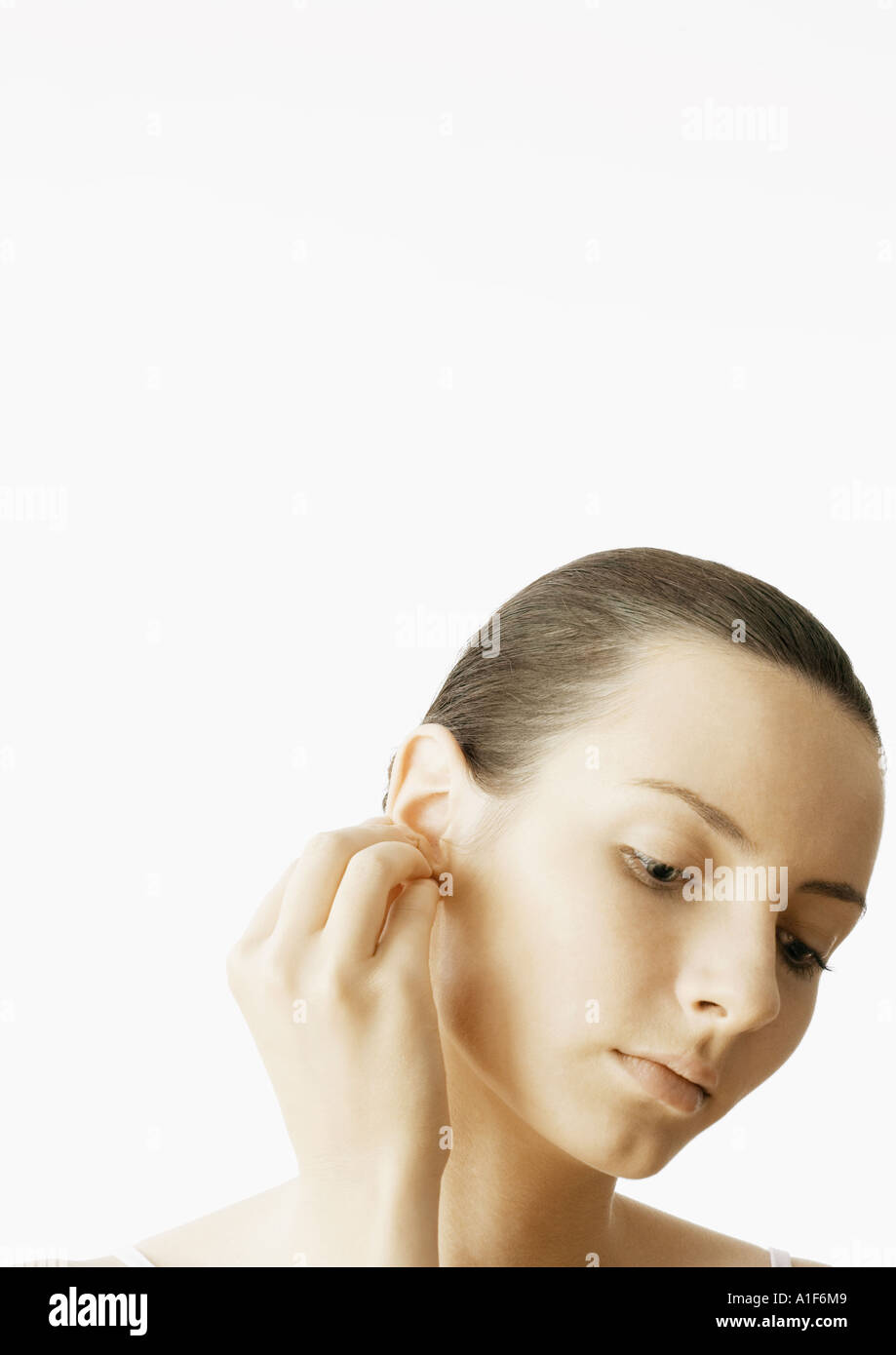 Woman touching ear Stock Photo - Alamy