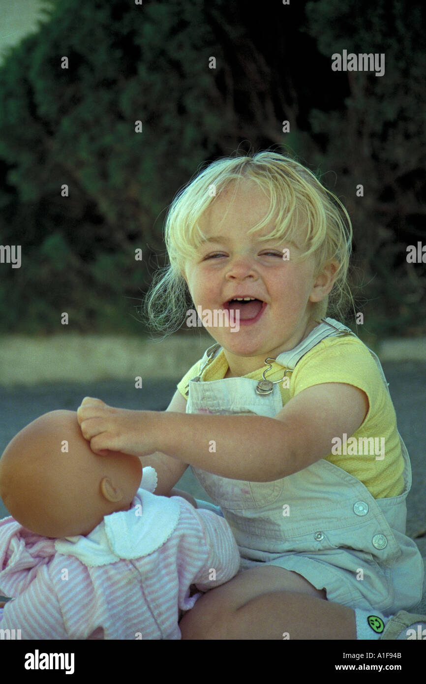 little girl playing with her baby doll Stock Photo - Alamy