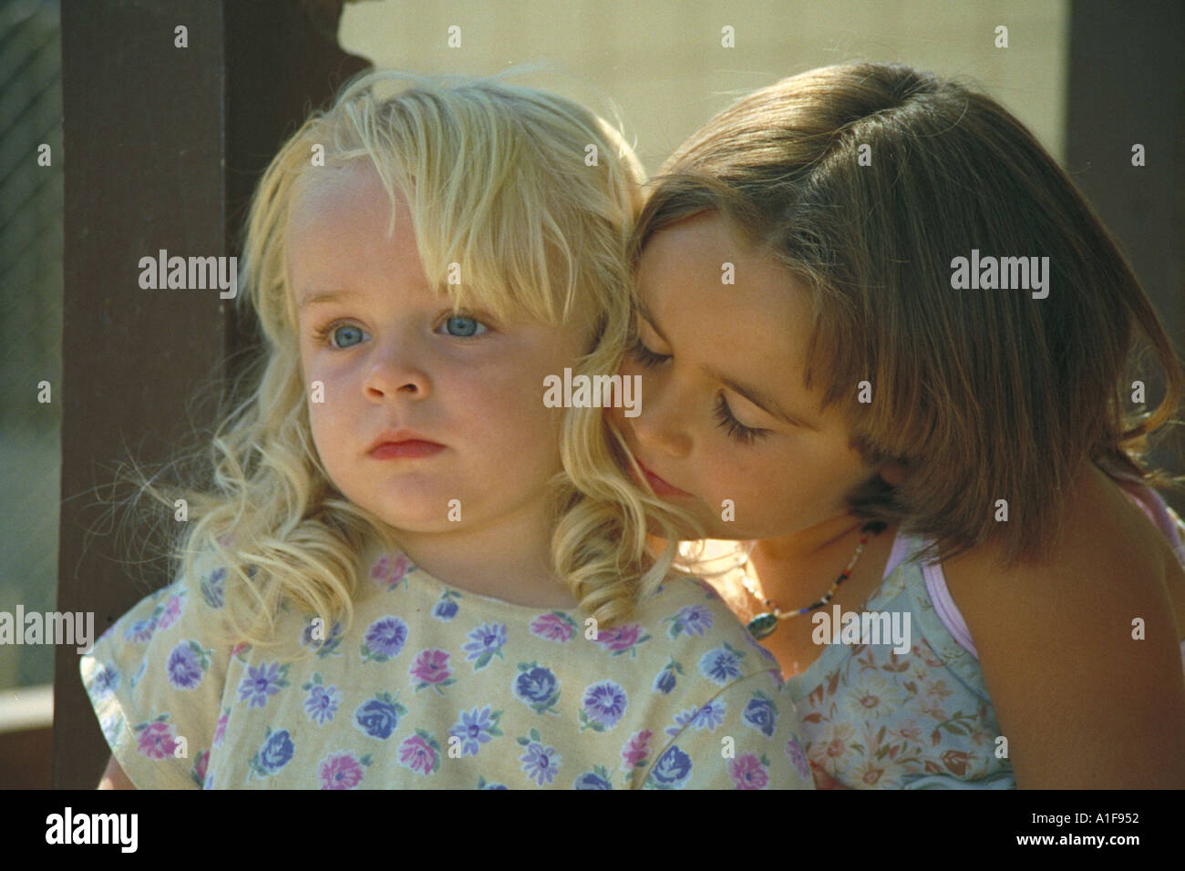 two young girls sharing a tender moment Stock Photo - Alamy