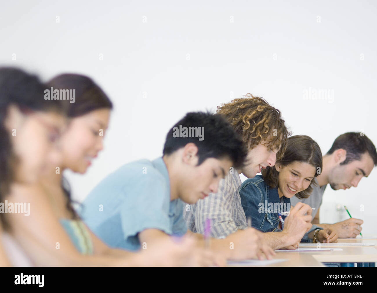Students sitting side by side in class, doing class work Stock Photo ...