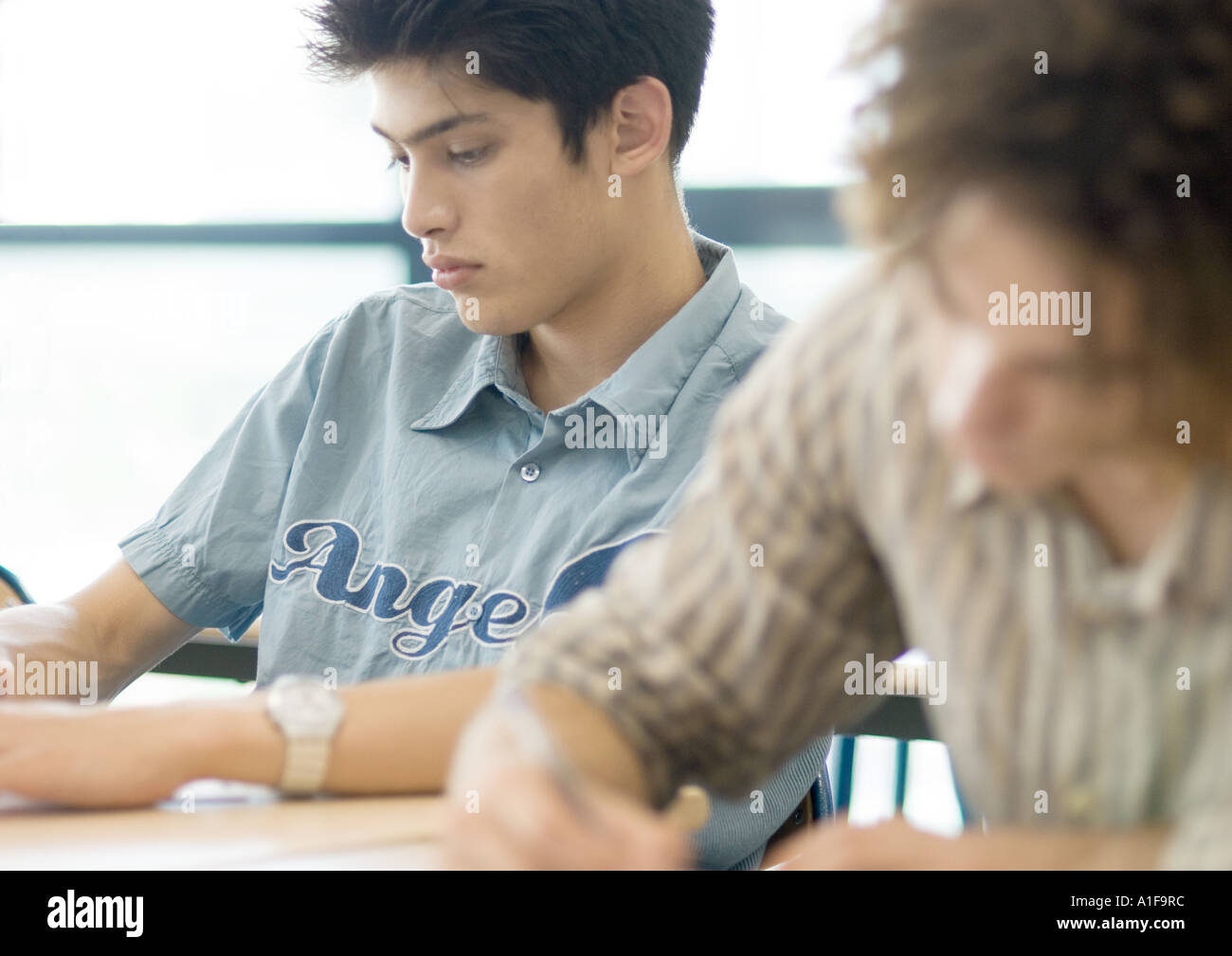 Two male students writing in class Stock Photo - Alamy