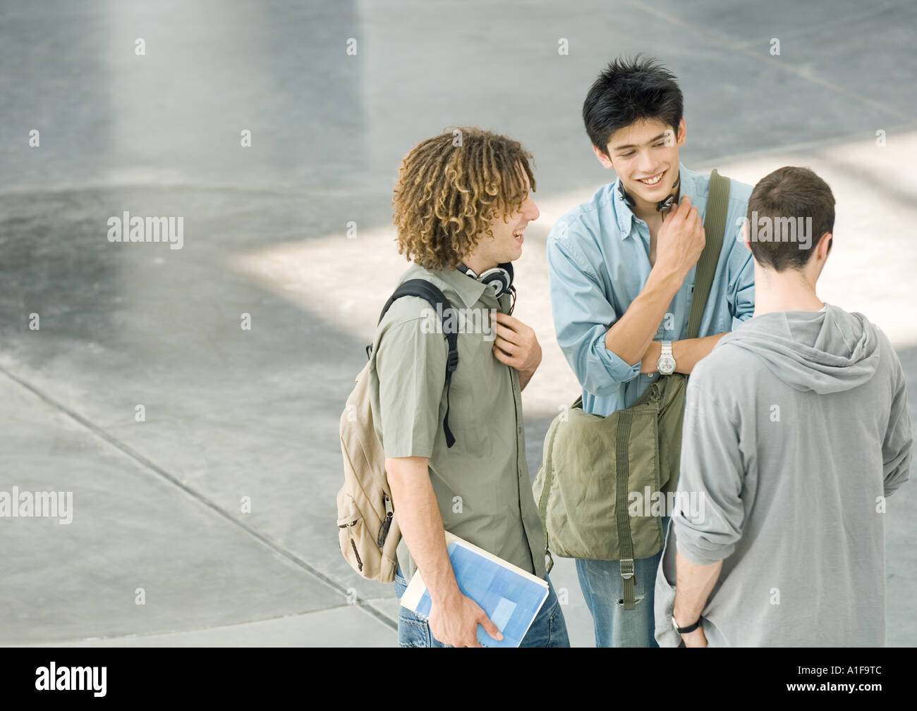Three male students standing together, talking Stock Photo - Alamy